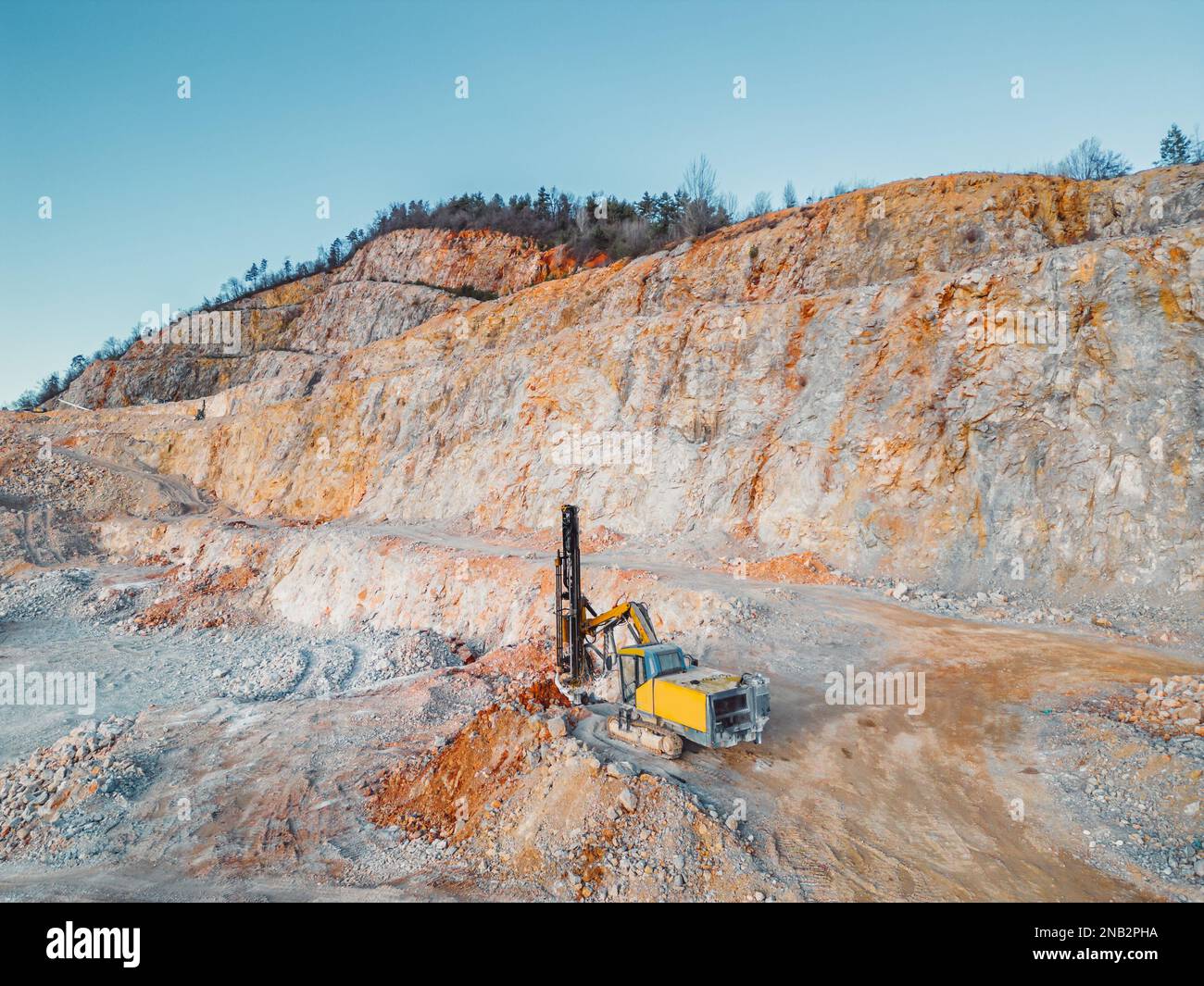 Yellow excavator digging rocks at the quarry, doing all the hard work ...