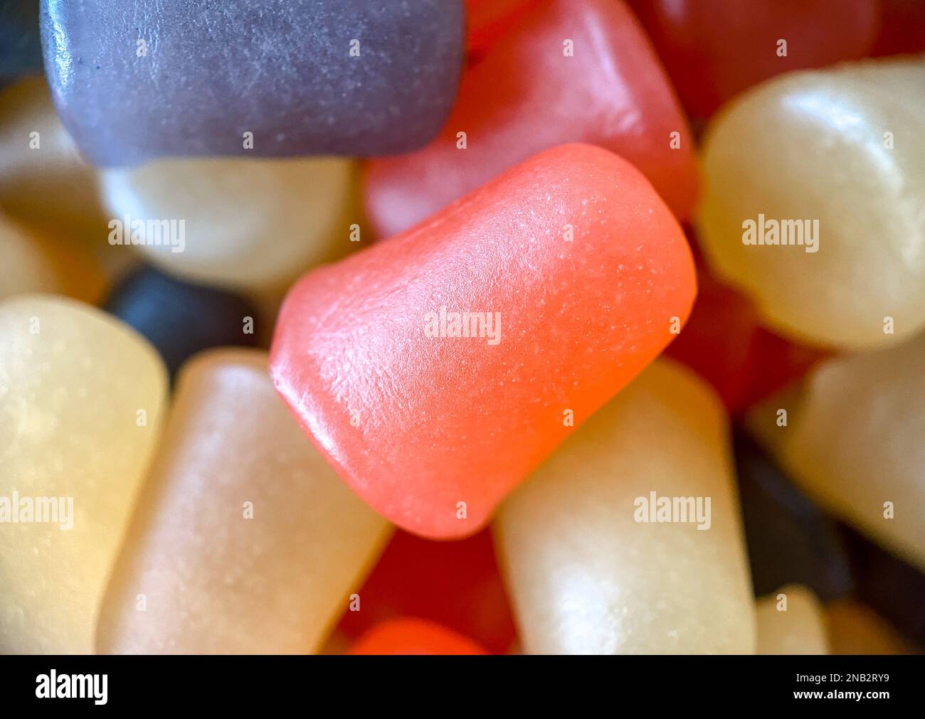 Close-up texture of yellow, red and pink multivitamin tablets in form ...