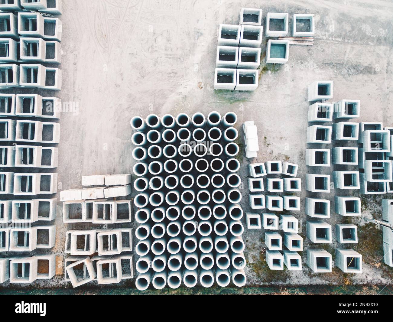 Looking down at concrete blocks and pipes neatly stacked in rows on the ...