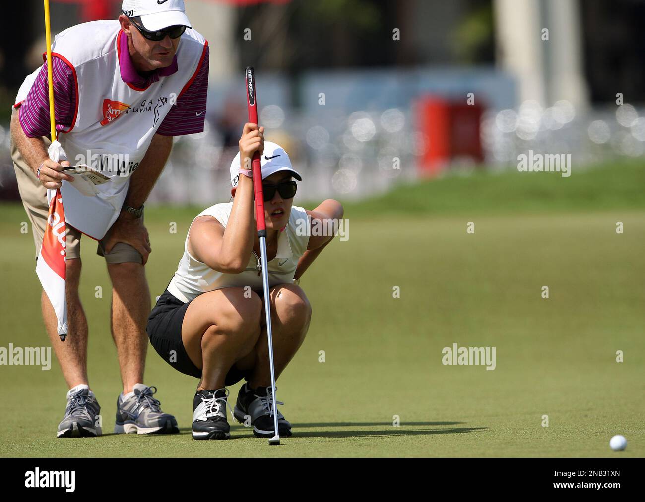 Michelle Wie, right, of the United States lines up her putt on the 18th ...
