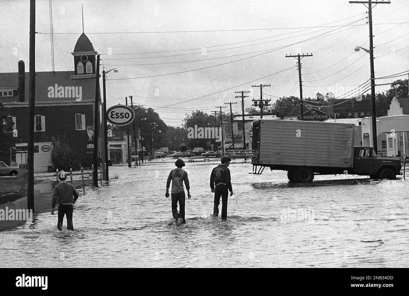 Three boys walk down flooded Main Street in downtown Belhaven, N.C., on ...