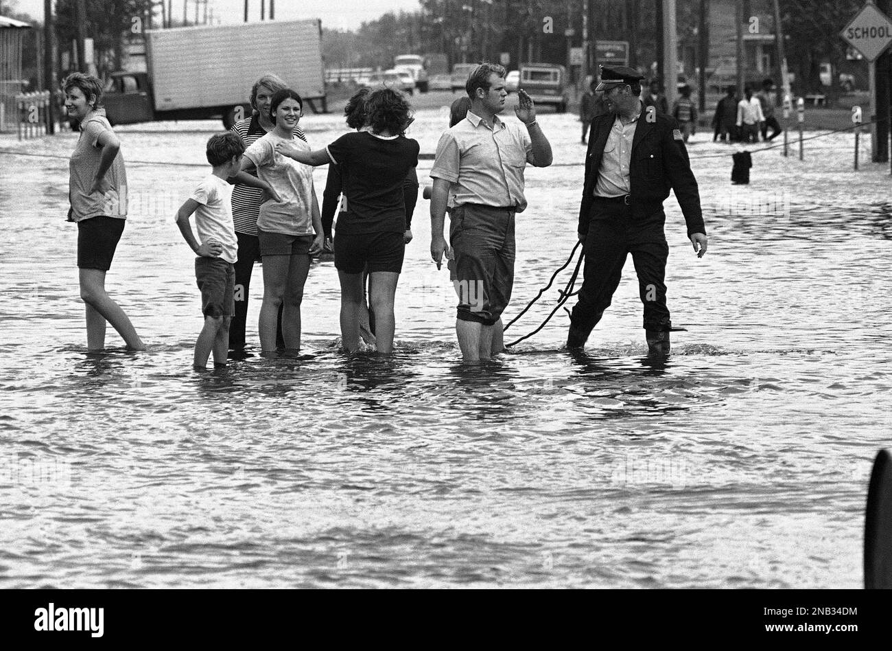 People walk down flooded Main Street in downtown Belhaven, N.C., on Oct ...