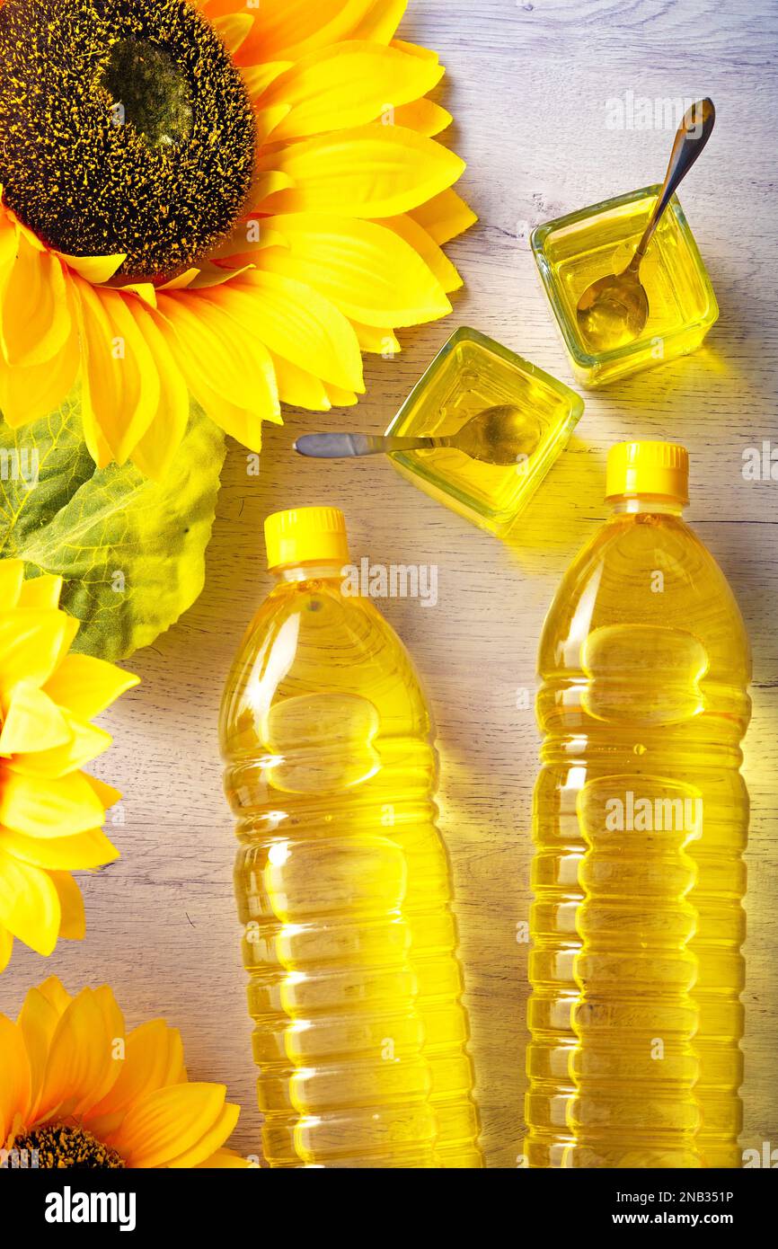 Plastic bottles with sunflower oil, fresh yellow sunflowers.Flat top ...