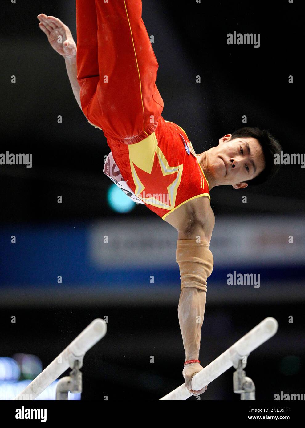 China's Teng Haibin performs on the parallel bars during the men's team ...