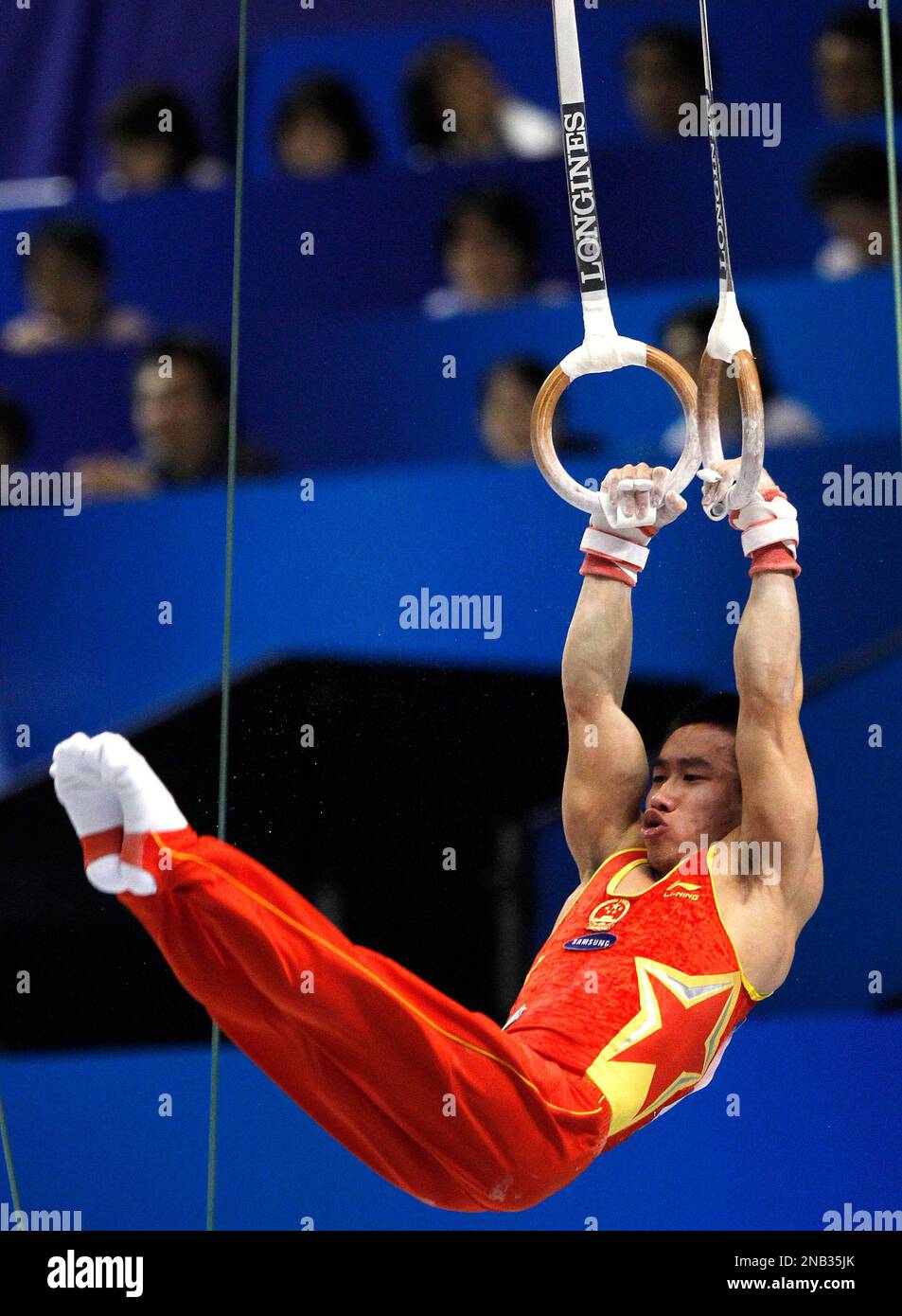 China's Yan Mingyong performs on the rings during the men's team final ...