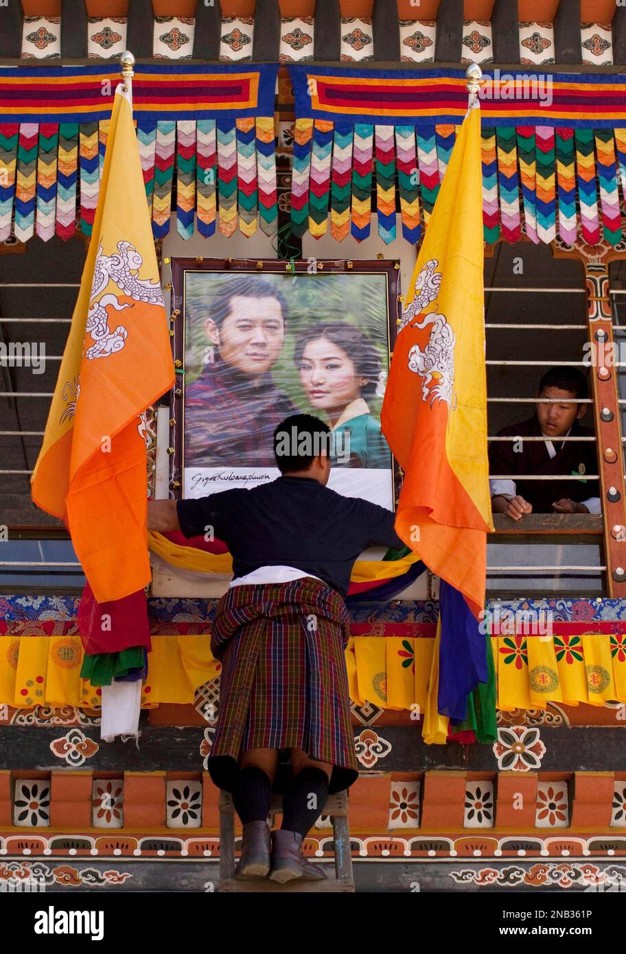 A Bhutanese staff member places a ribbon under a portrait of King Jigme ...