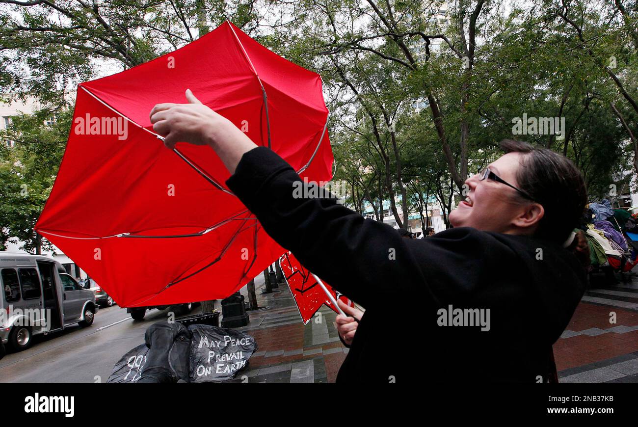 Kimbrie Sauvageau tries to turn her umbrella right-side out after it ...