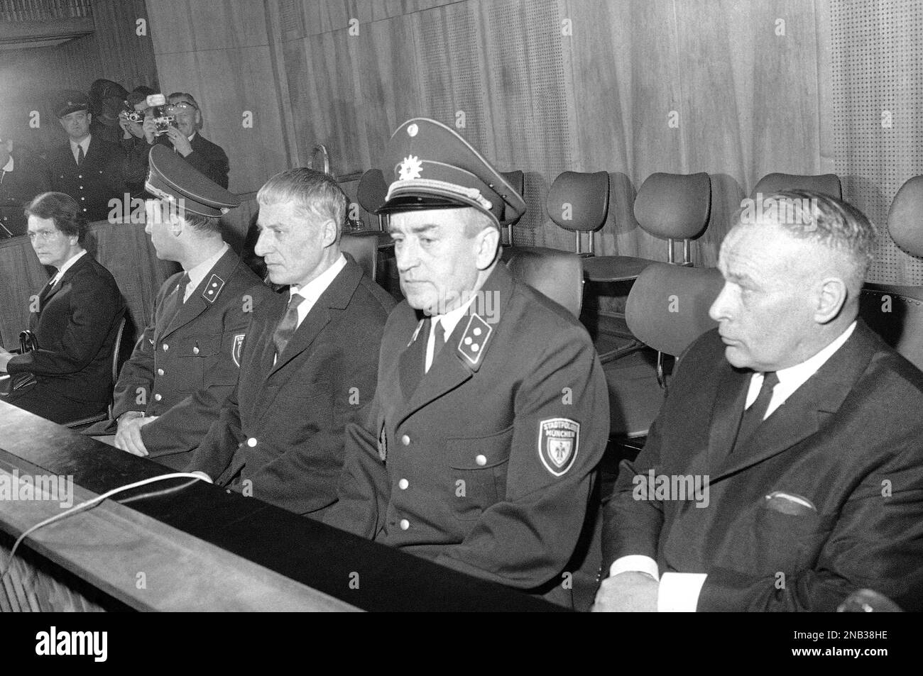 Three former Nazi officials sit with uniformed West German guards as ...