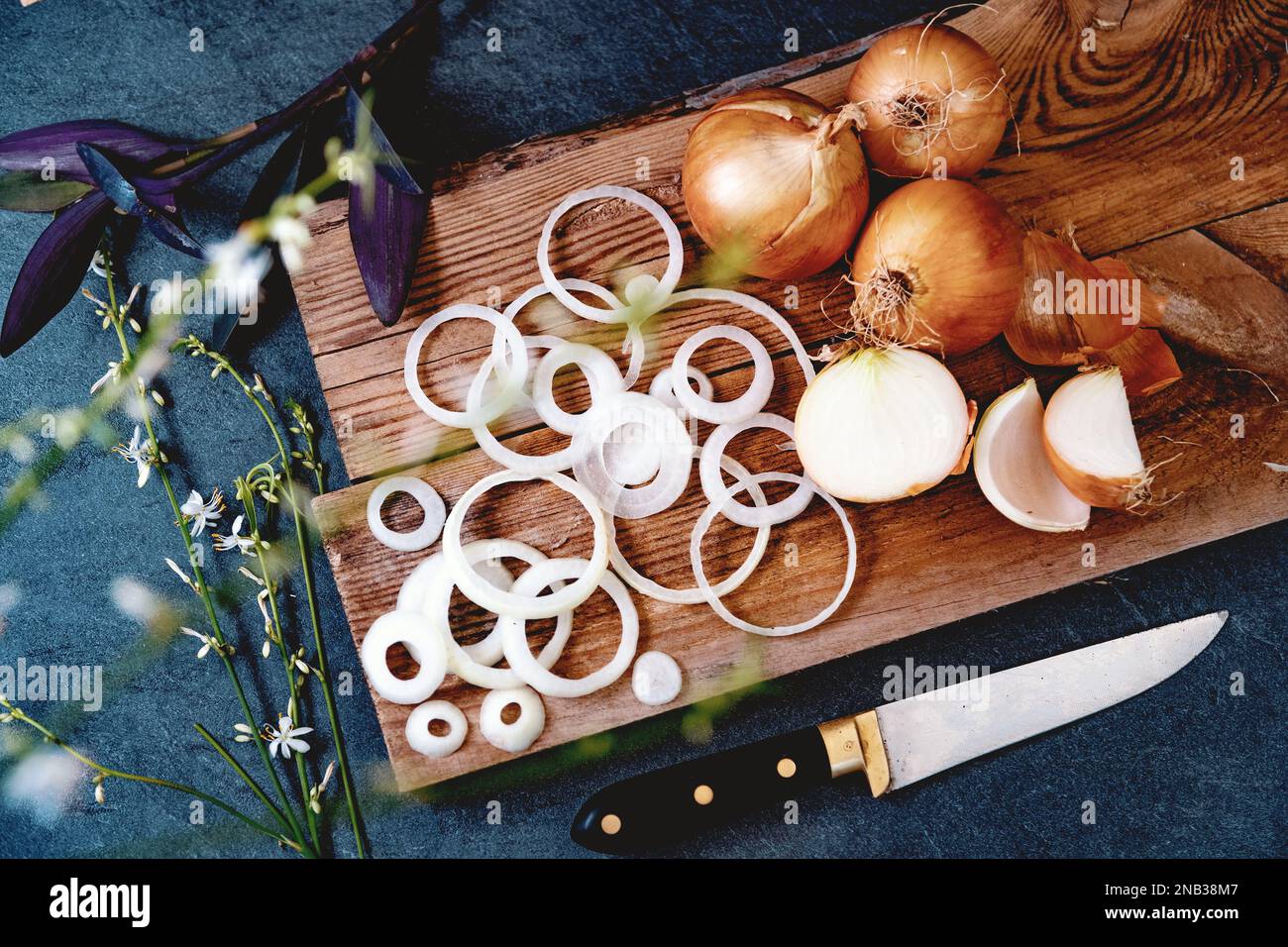 A lot of onions in a basket and plates on a dark and elegant dark ...