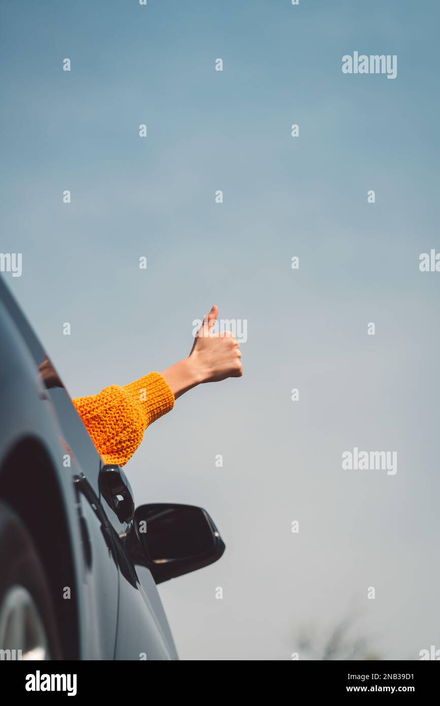 Vertical photo of persons hand sticking out the car window holding ...