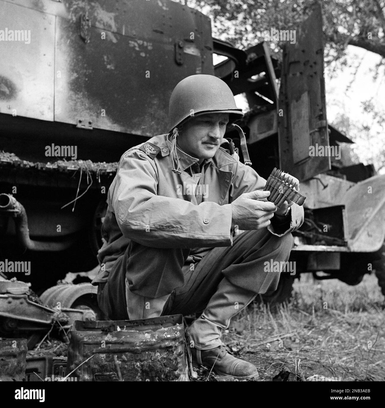 Don Whitehead looks at part of a clip of machine gun bullets, the rest of which exploded from ...
