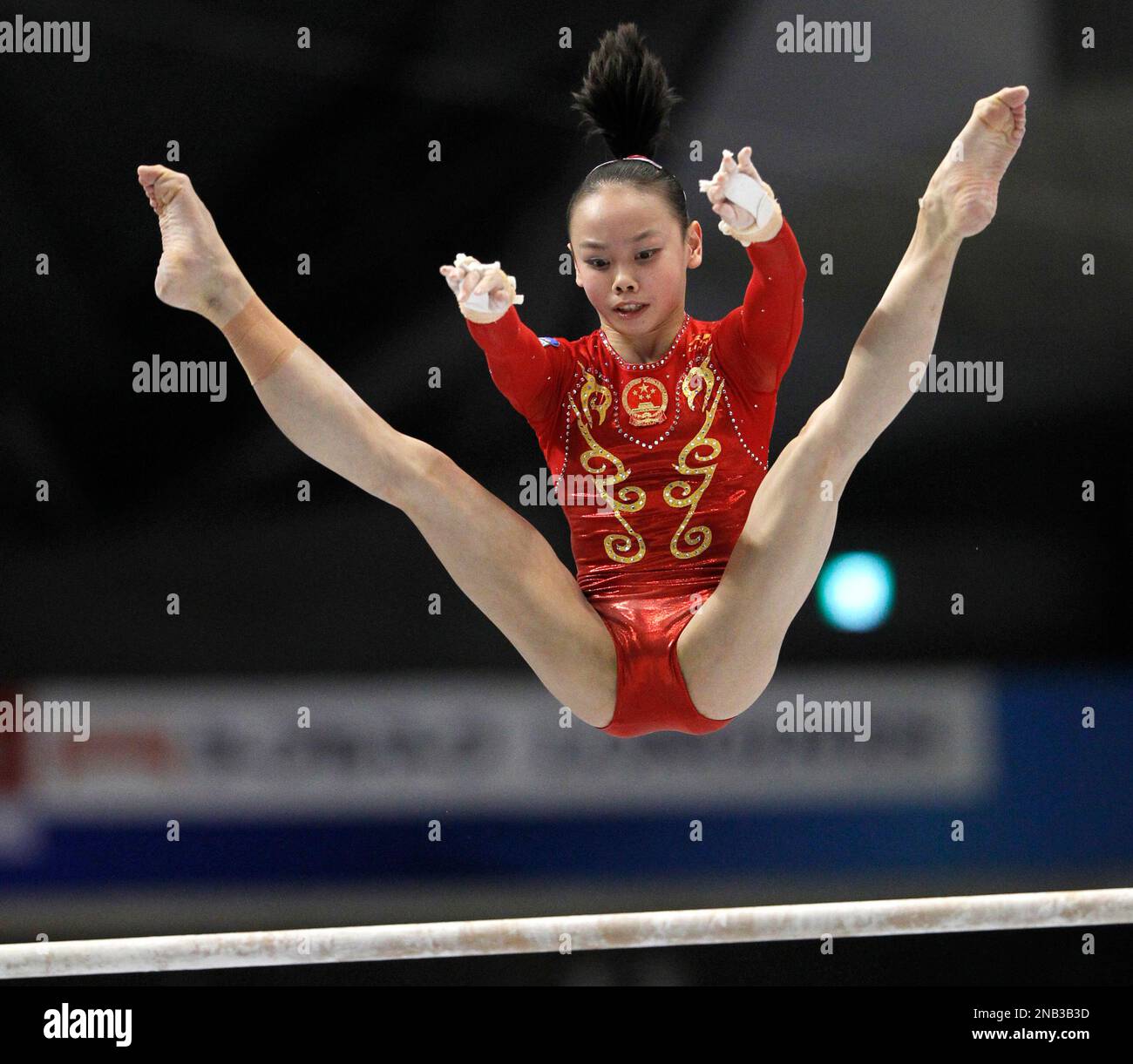 China's Tan Sixin performs on the uneven bars during the women's team ...