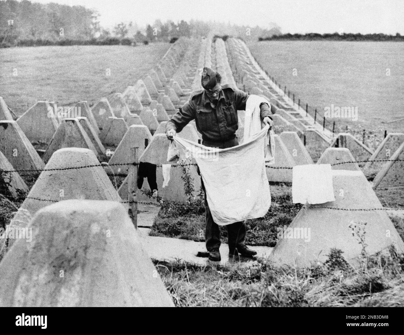 A Royal Air Force man hangs his wash across the barbed wire on the ...