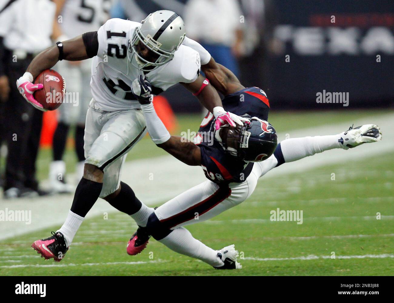 Oakland Raiders wide receiver Jacoby Ford (12) tries to push away from ...