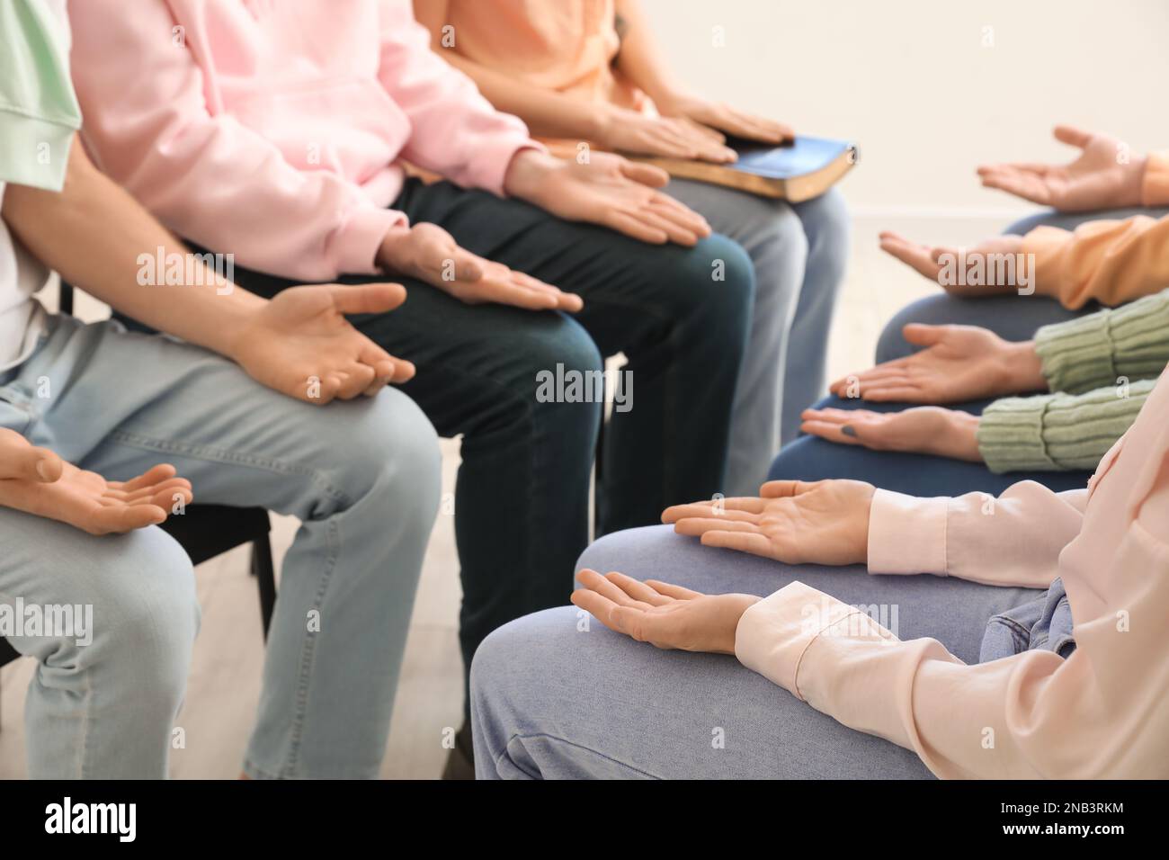 Group of people praying with Holy Bible in room Stock Photo - Alamy