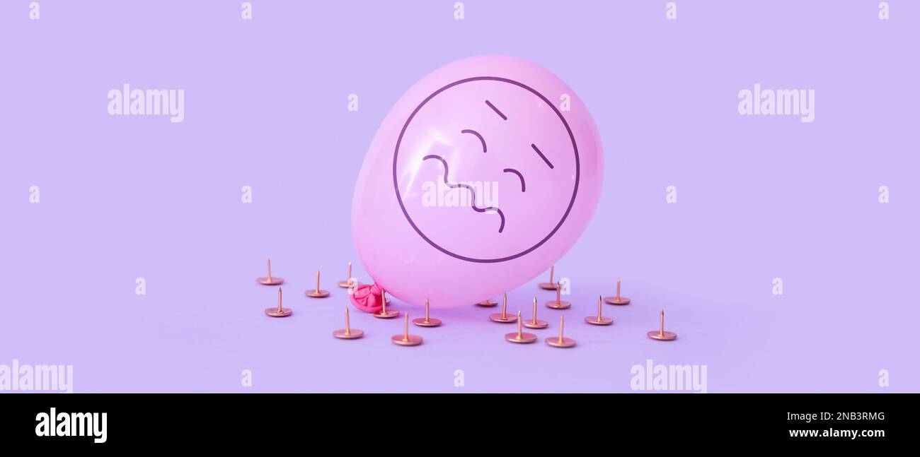 Paper pins and air balloon with drawn stressed emoticon on lilac ...