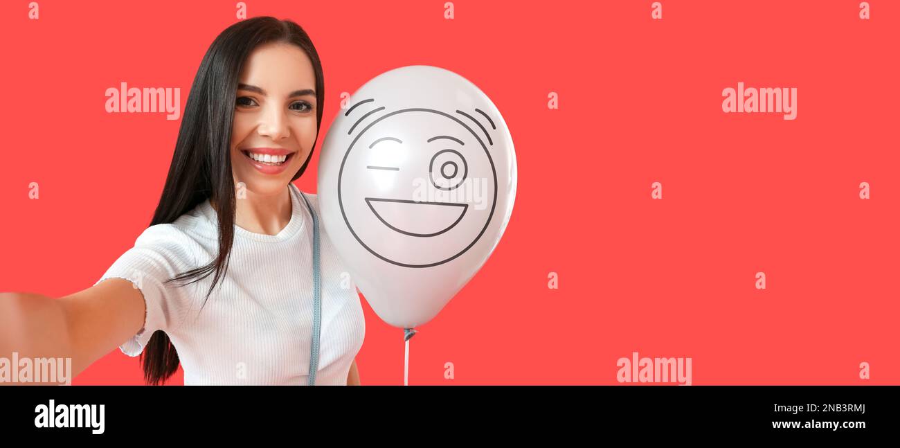Beautiful young woman and balloon with drawing happy emoticon taking ...