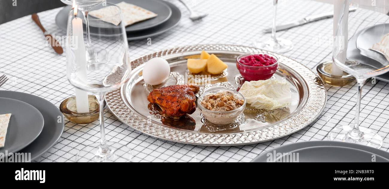 Passover Seder plate with traditional food on table in dining room ...