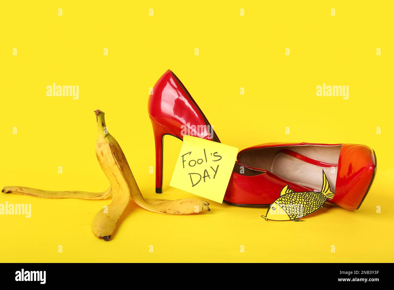 Stylish high-heeled shoes, banana peel, paper fish and sticky note with ...