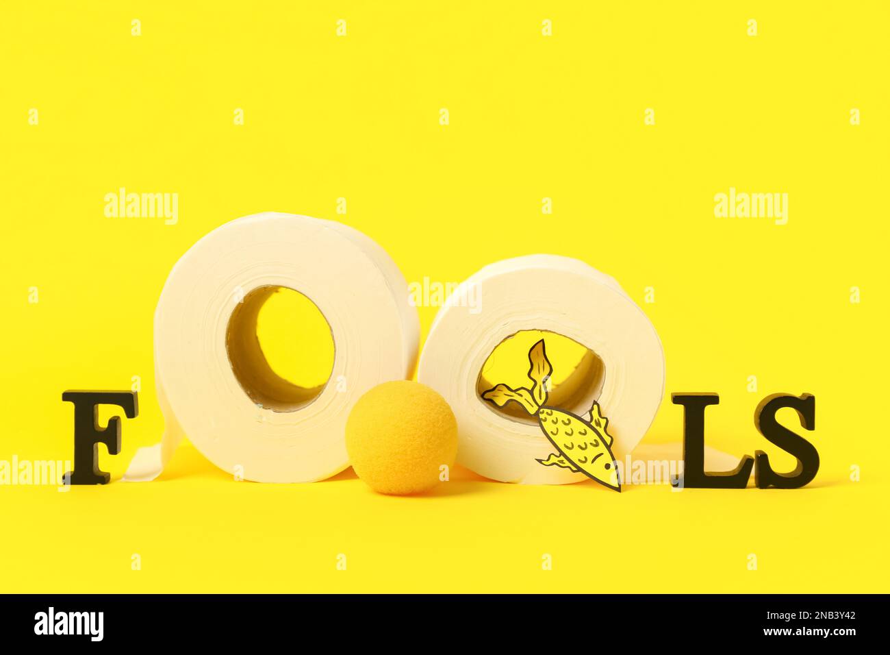 Word FOOL'S made of letters, toilet paper and clown nose on yellow ...