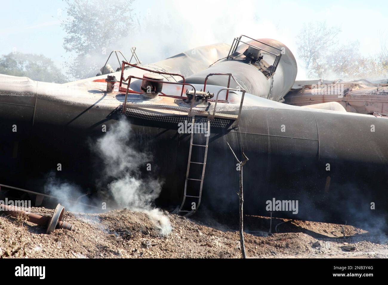 Rail cars lie in a smoldering heap after a freight train loaded with ...