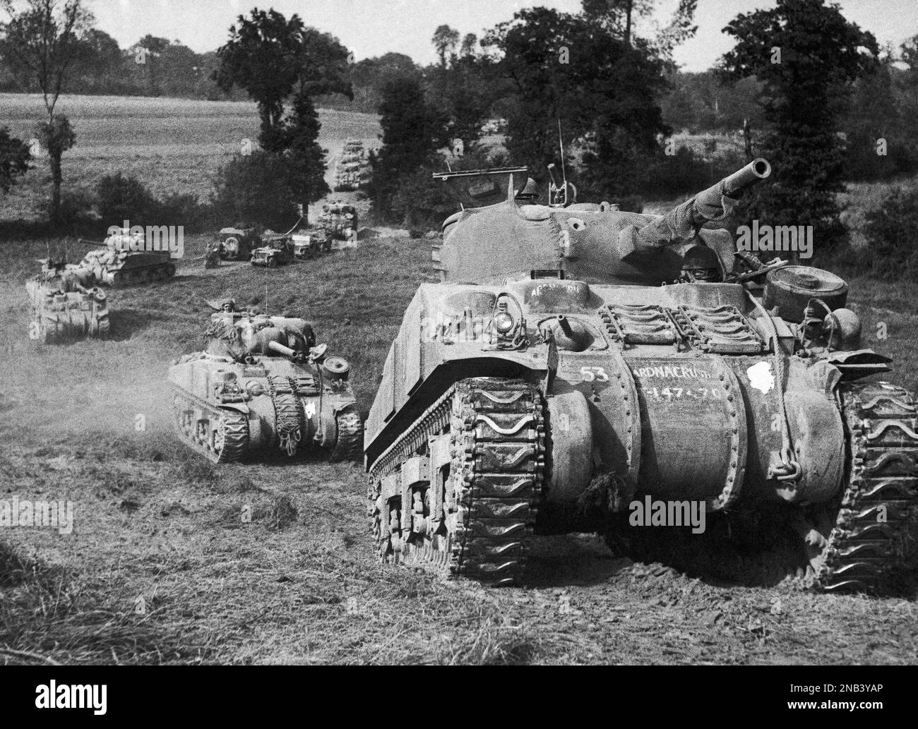 A column of British-manned Sherman tanks rumbles through rolling ...