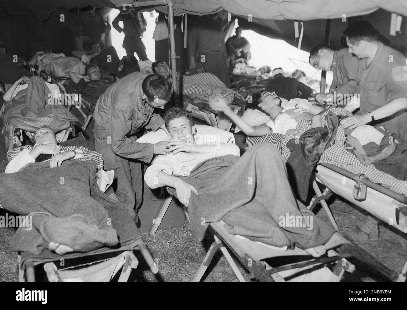 U.S. Army medical orderlies administer help to wounded soldiers in the ...