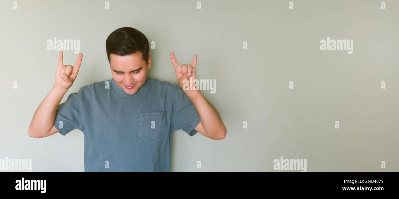 A Young man making happy rock and roll sign with space for text Stock ...
