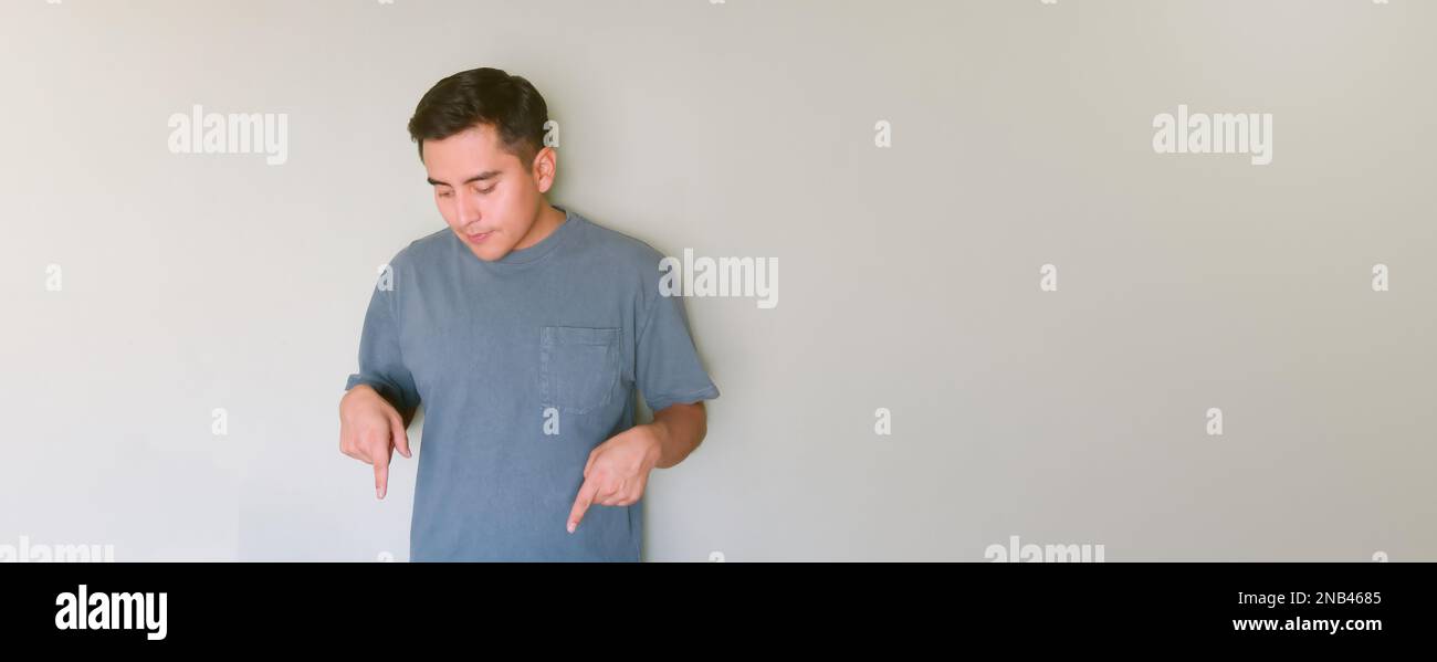 A Young man pointing down with fingers, space for text Stock Photo - Alamy
