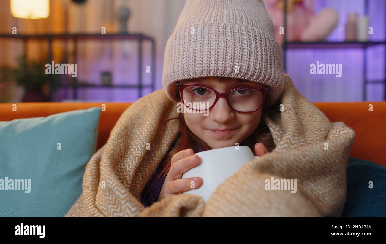 Sick toddler girl wear hat wrapped in plaid sit alone shivering from ...