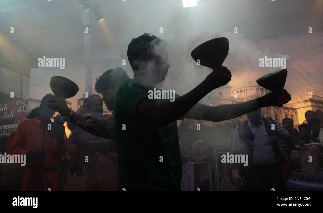 Hindu devotees hold pots of holy smoke while dancing as a part of ...