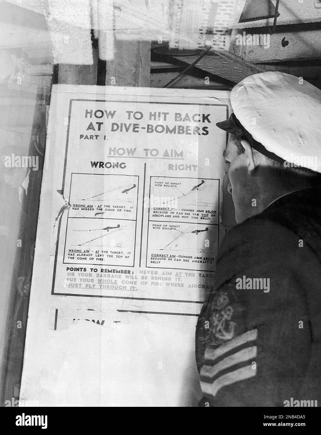 A British officer of the battleship Warspite studies a chart showing ...