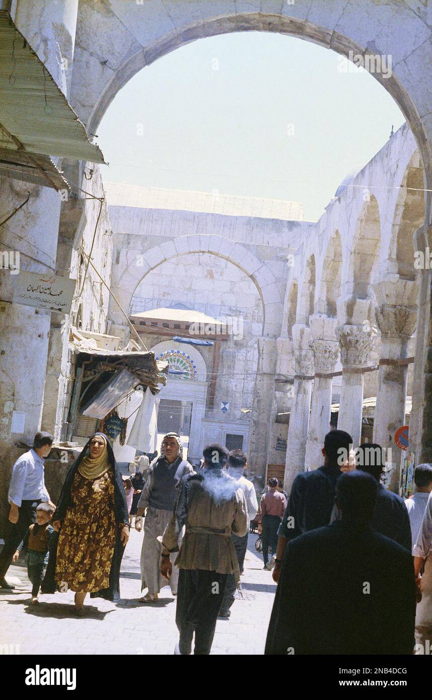 The colorful costumes of Arabia mingle in the crowded bazaar section of ...