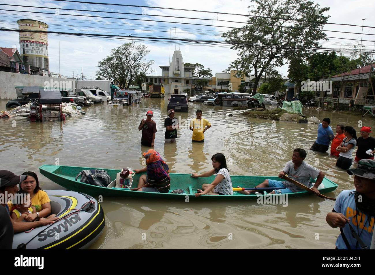 Residents use boats and floaters for transport as flooding continues at ...