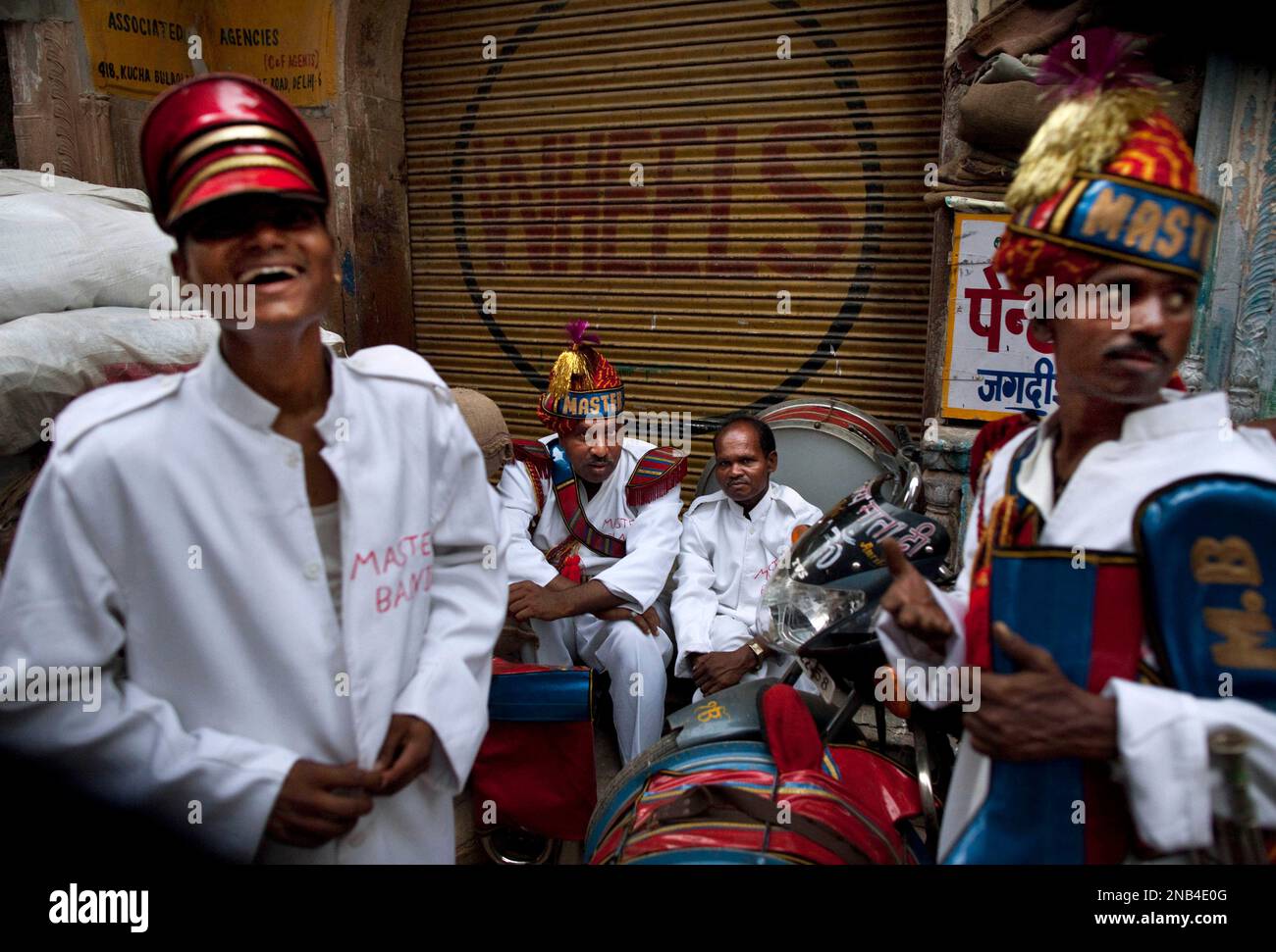 Members of an Indian marching band relax in an alleyway before playing ...