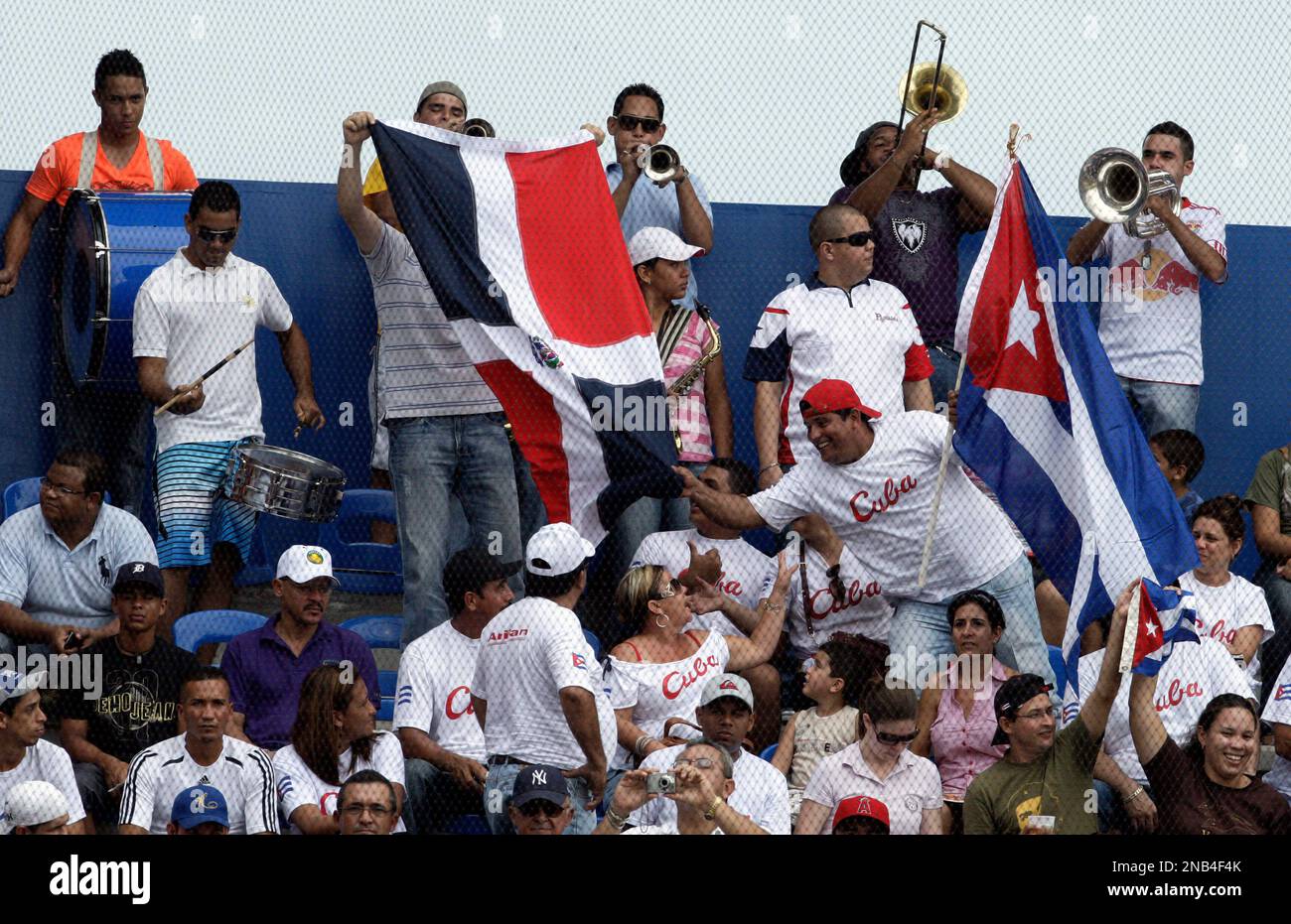 Baseball fans holding the flags of Cuba, right, and the Dominican ...