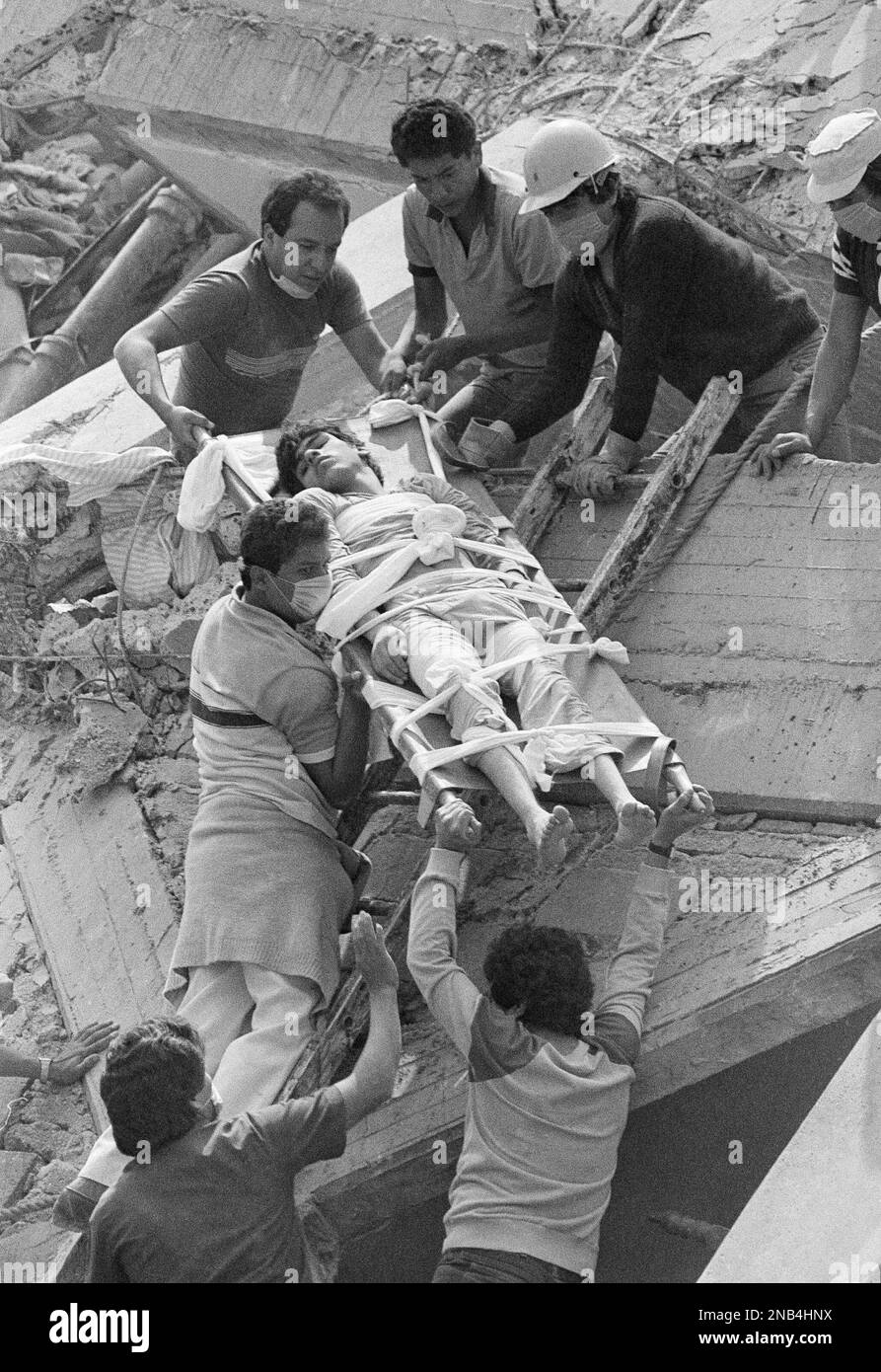 Rescue workers lower one of the injured earthquake victims from a ...