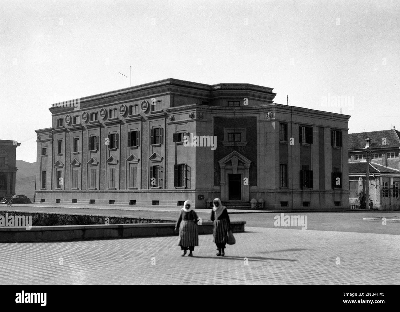 A fine newly built structure in stone, with two peasant women striking ...