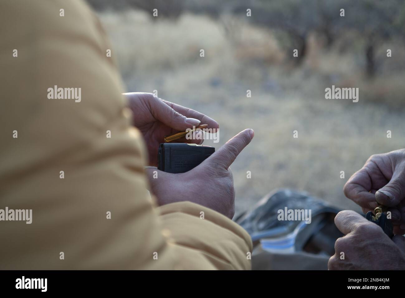 Man loading rifle magazine with ammunition Stock Photo - Alamy