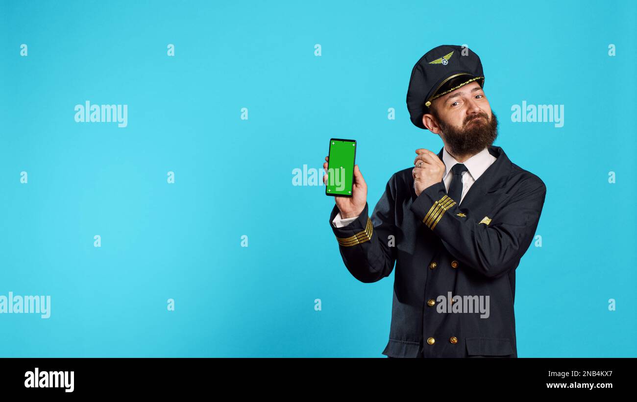 Positive aircrew captain showing phone with greenscreen, holding ...