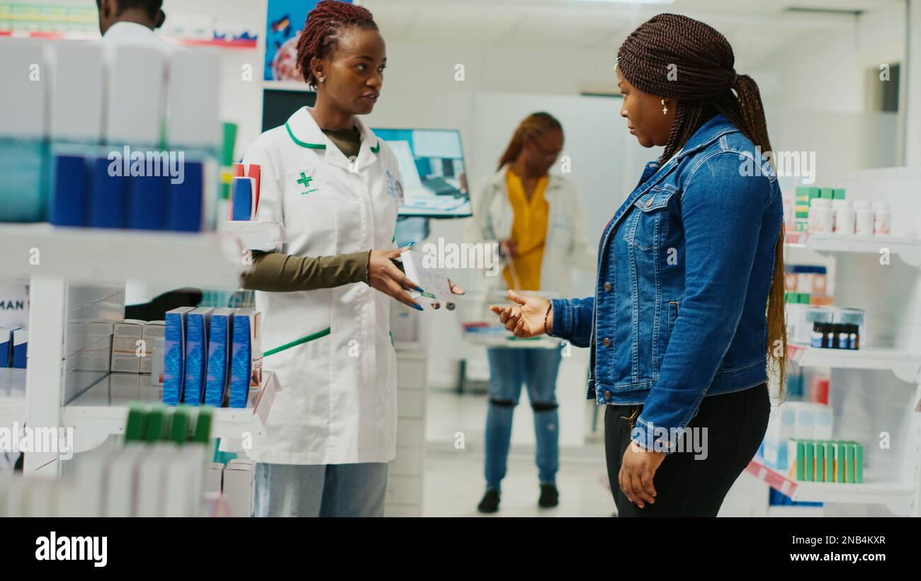Woman pharmacist helping customer with medication in pharmaceutical ...