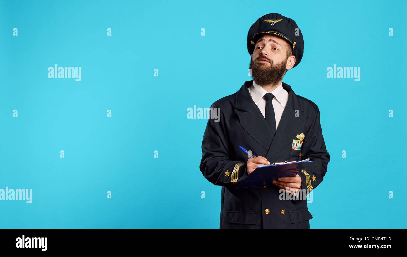 Confident aircrew captain checking list on papers, taking notes with ...