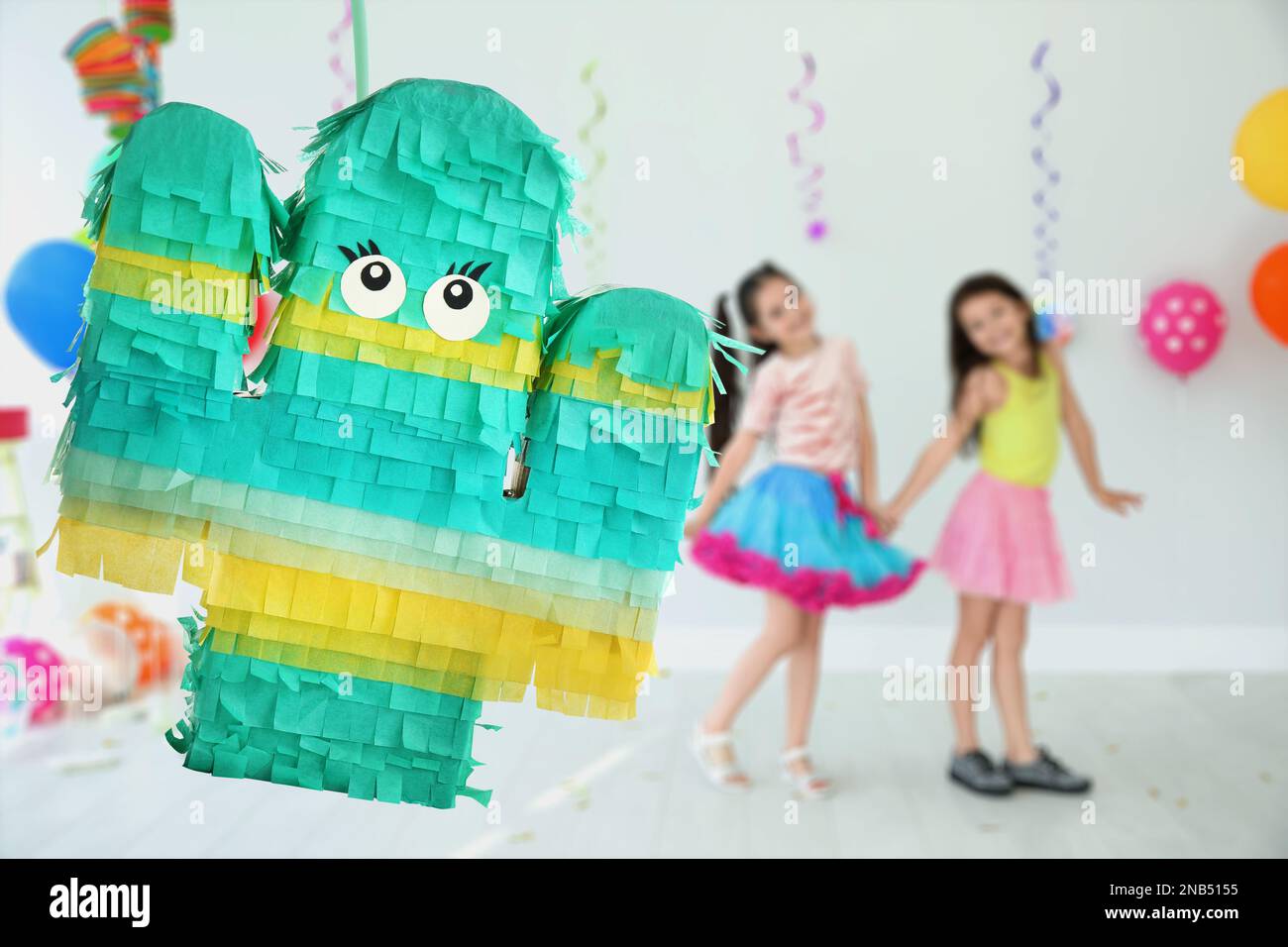Bright festive pinata hanging indoors at birthday party, space for text ...