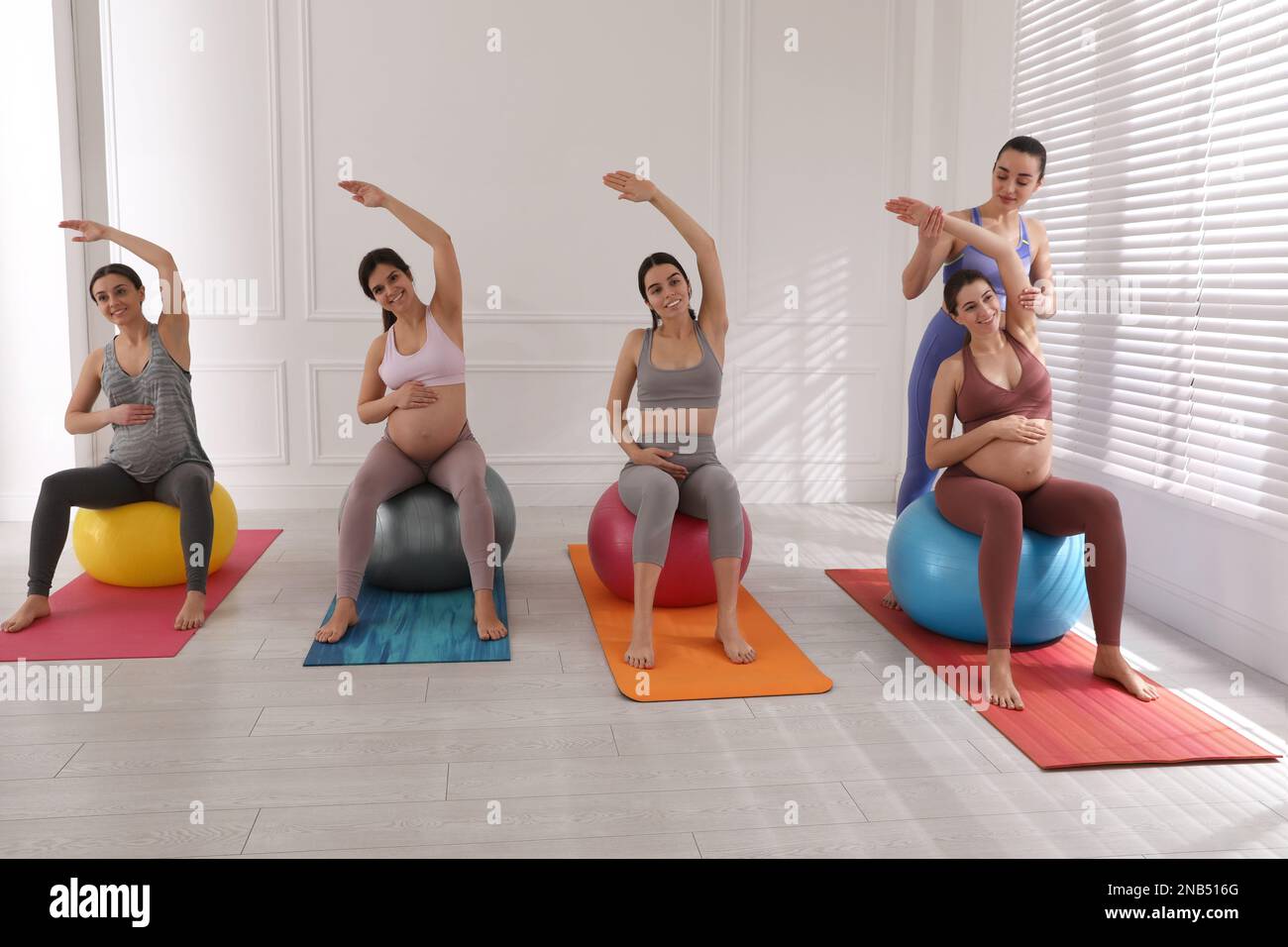 Trainer working with group of pregnant women in gym. Preparation for ...