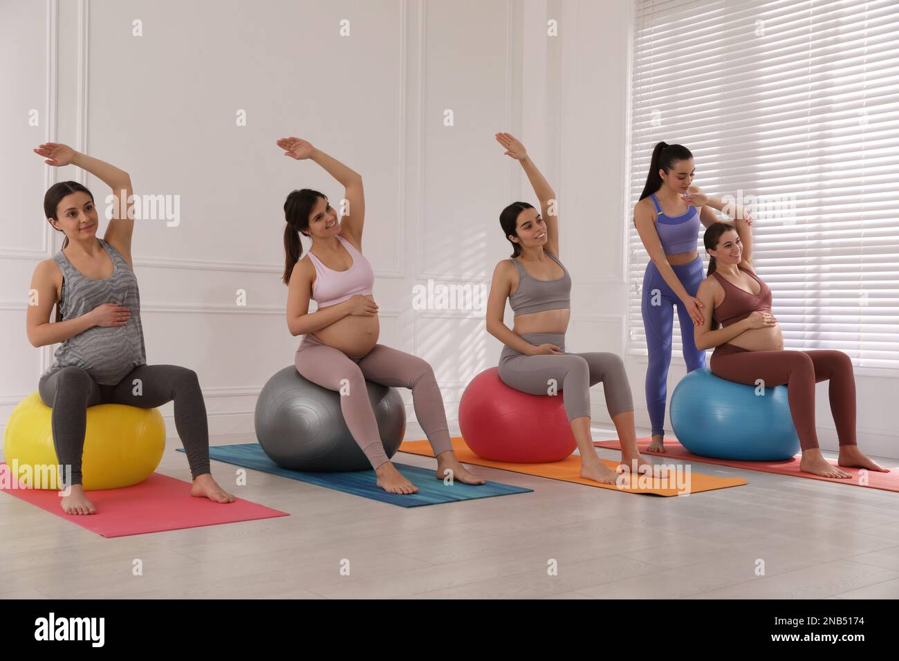 Trainer working with group of pregnant women in gym. Preparation for ...