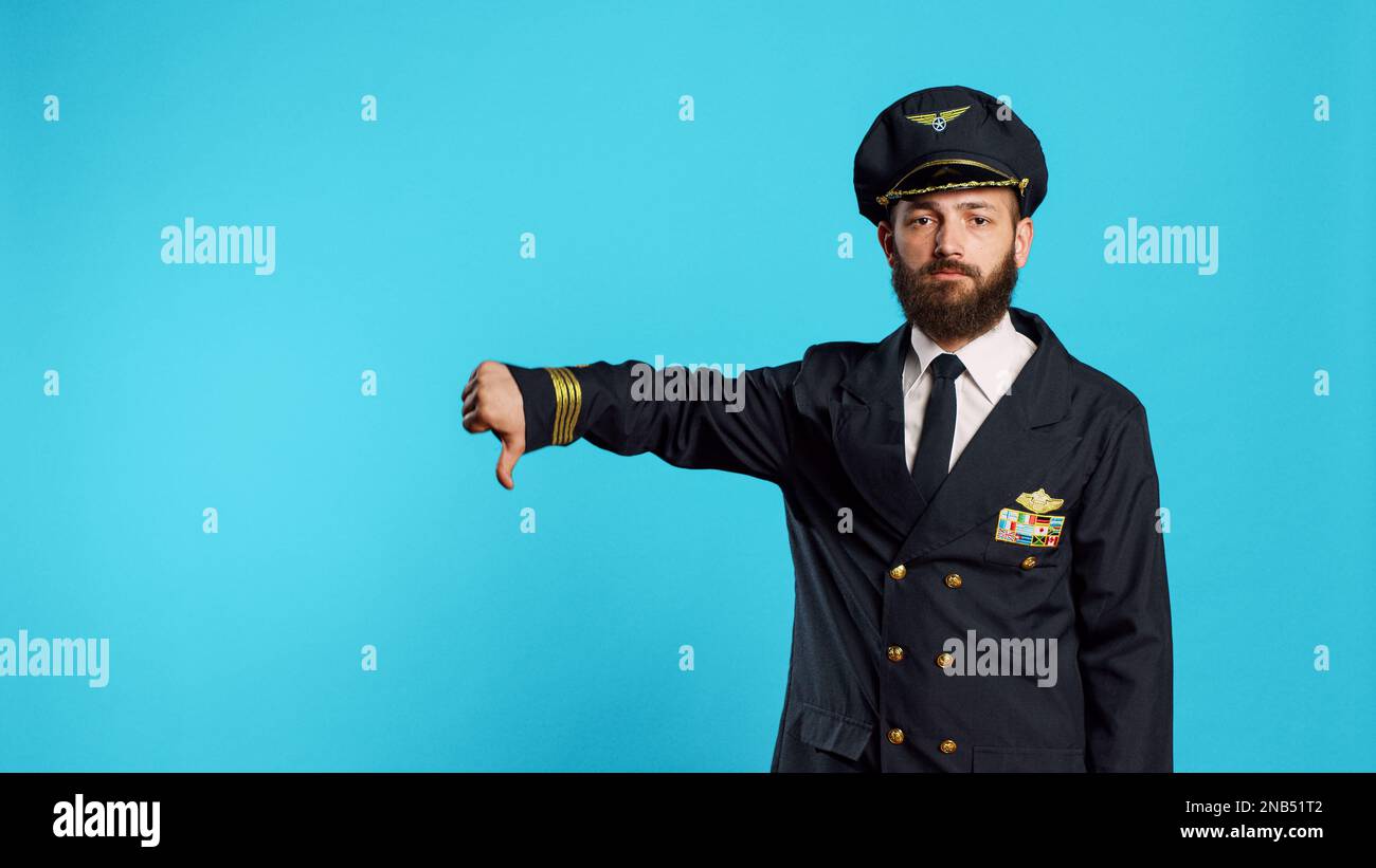 Professional aviator showing thumbs down sign, expressing dislike and ...