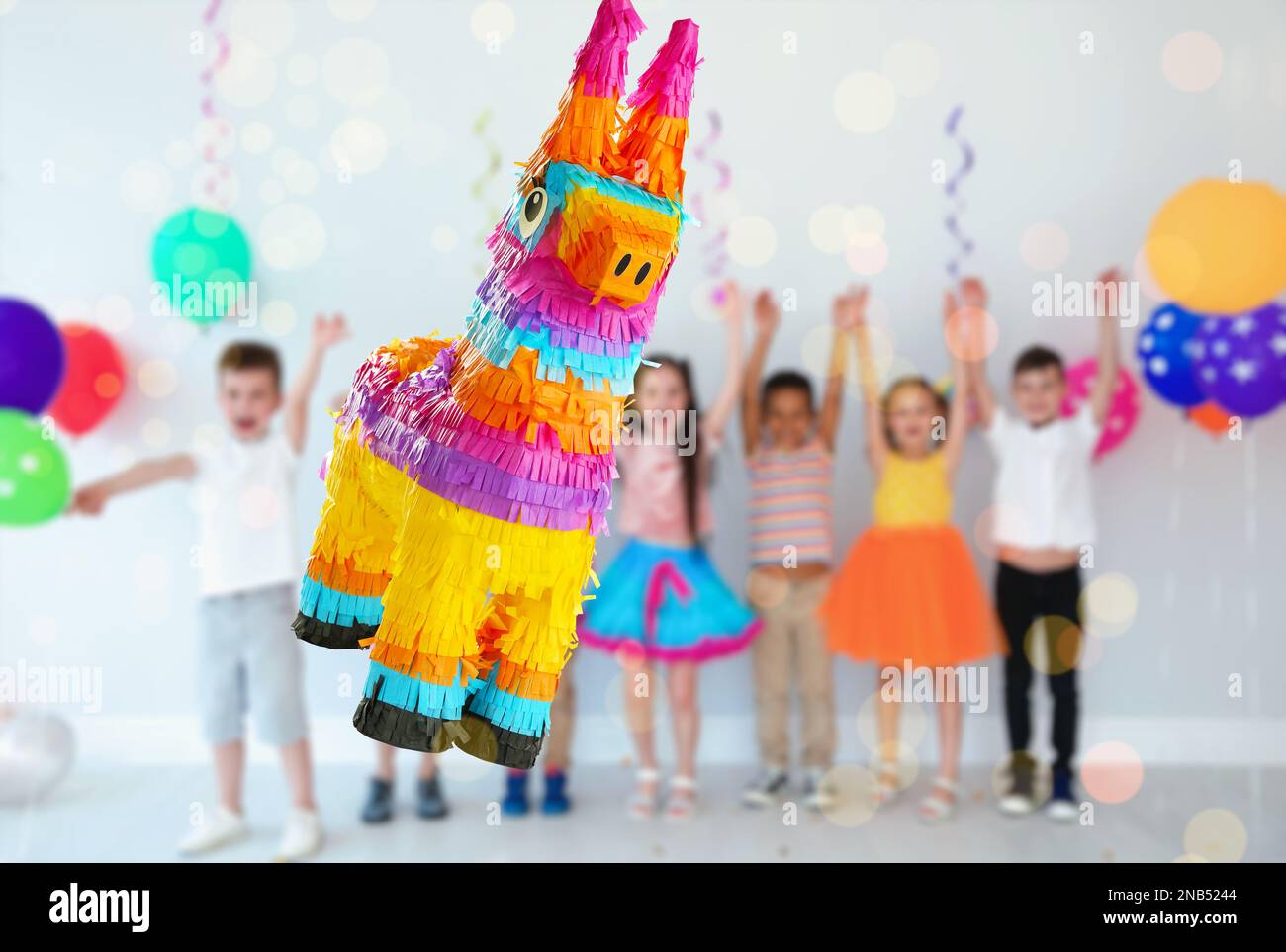 Bright festive pinata hanging indoors at birthday party, space for text ...