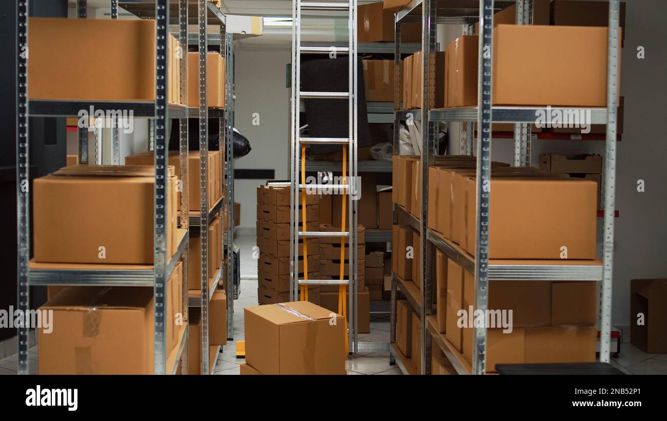 Empty office space in warehouse with carton boxes, desk with laptop and ...