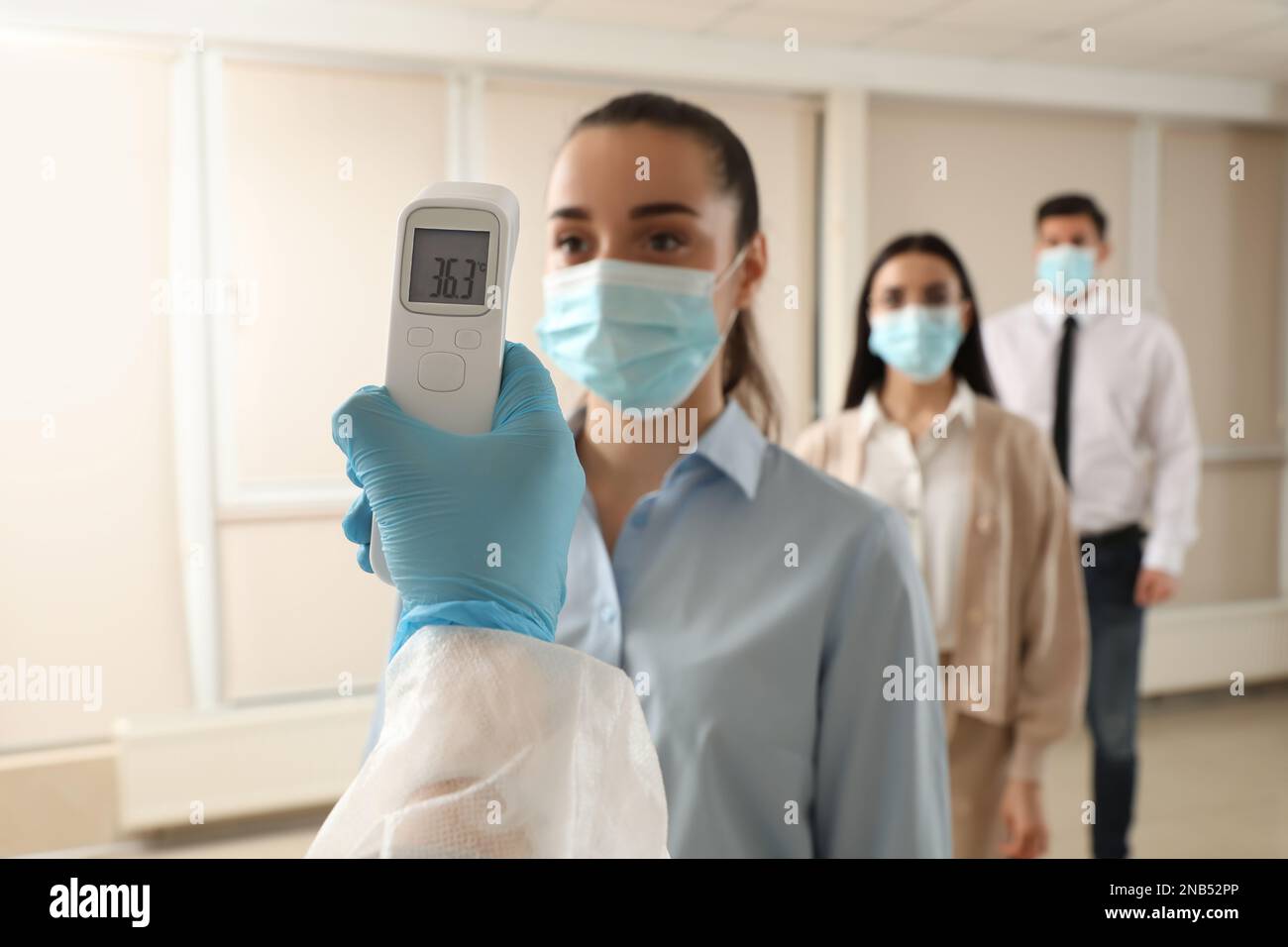 Doctor measuring employees temperature in office, closeup. Prevent ...