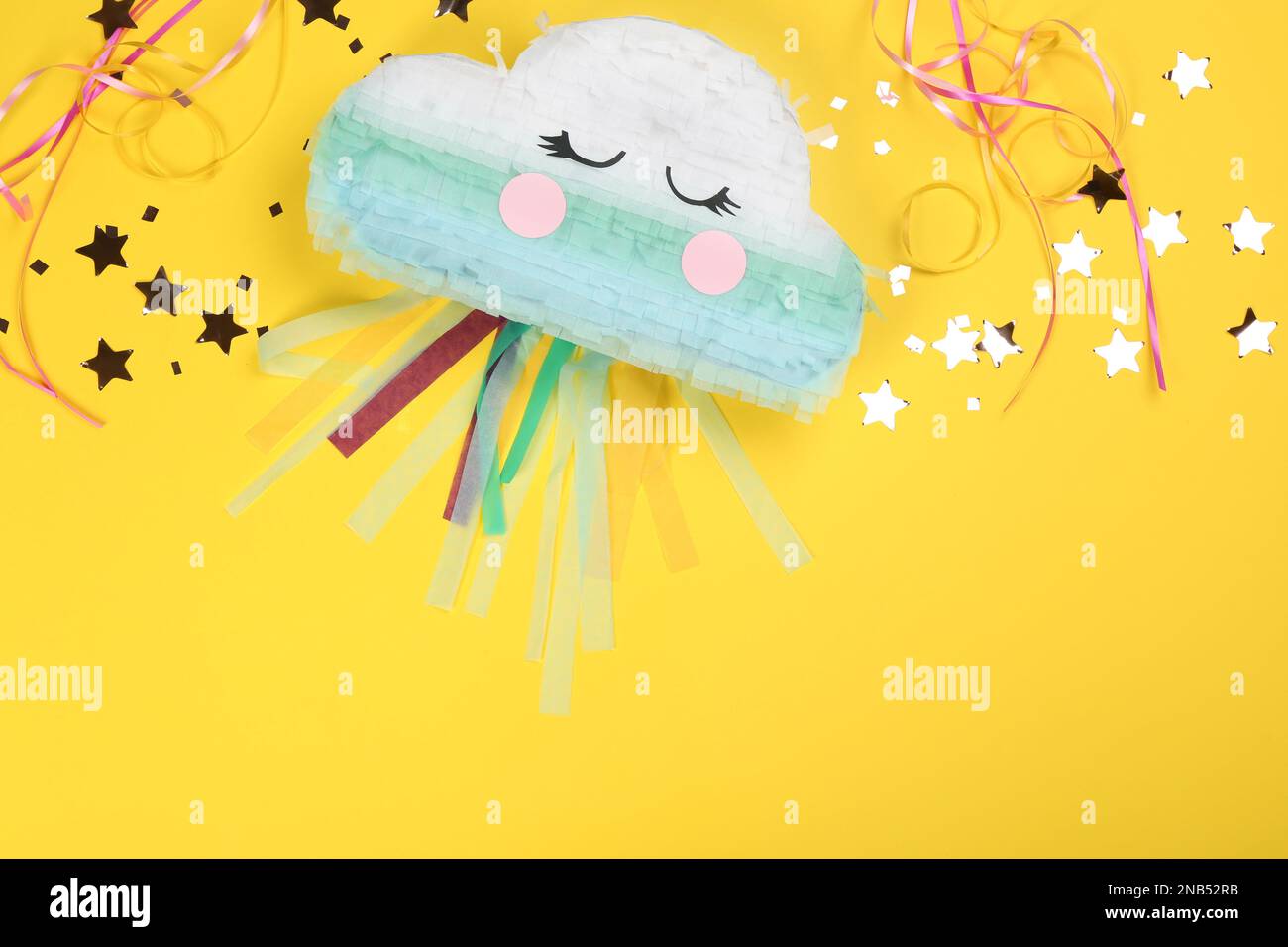 Bright cloud pinata and confetti on yellow background, flat lay. Space ...